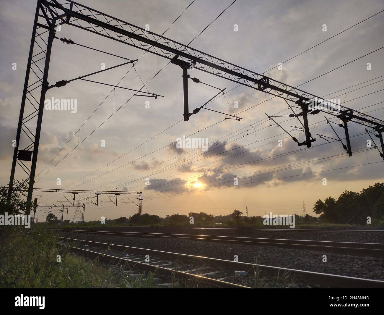 Overhead lines over the empty rail tracks against a blue cloudy sky ...