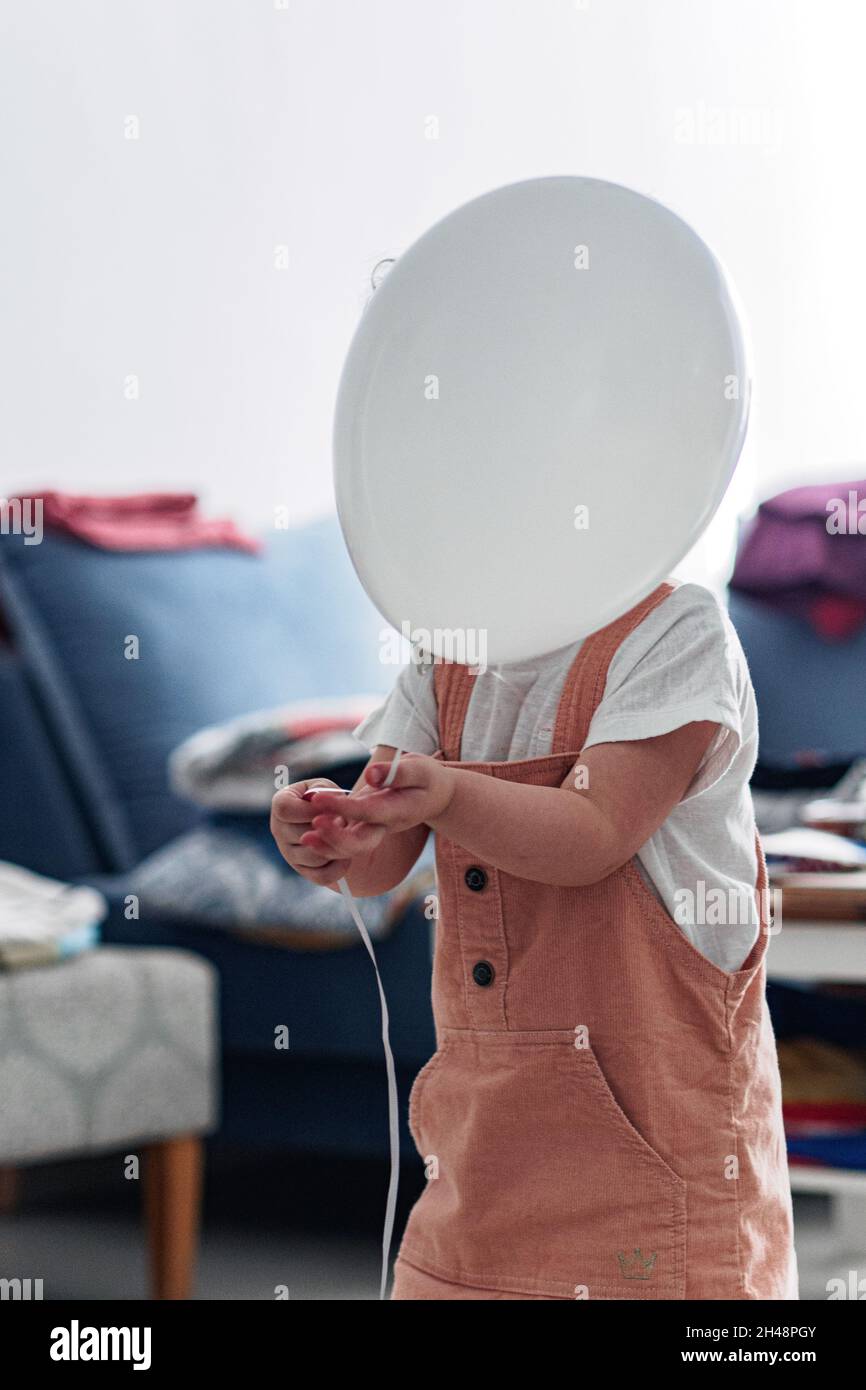 Young toddler plays indoors, alone with a ballon. Model Release ...