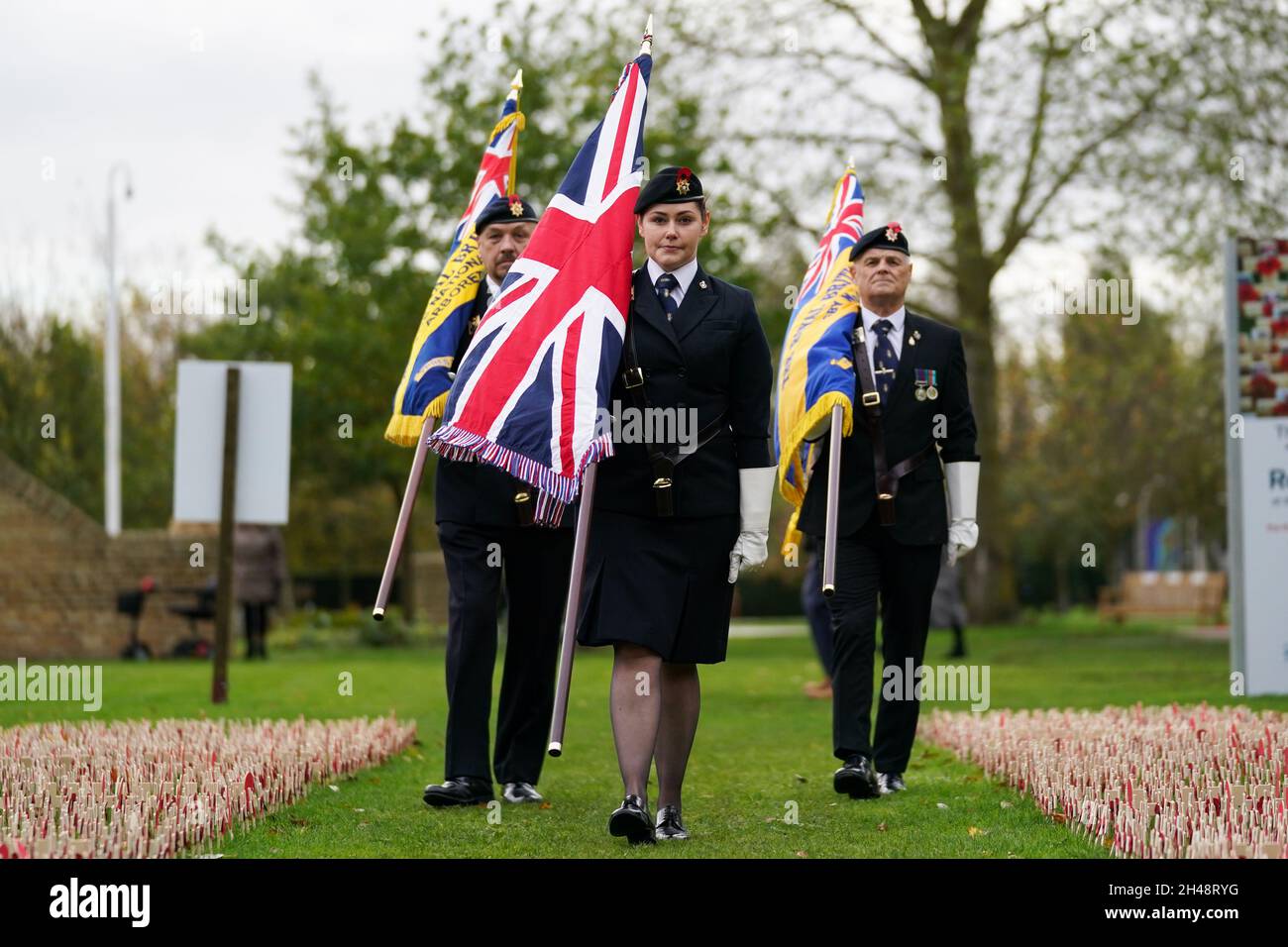 Flag bearers walk by the planted tributes during the official opening ...