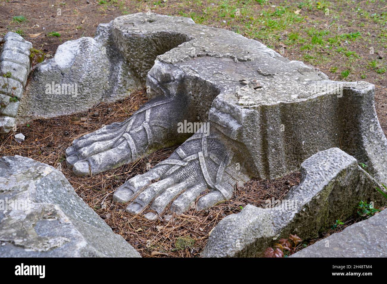 Remains of an ancient broken Greek style stone statue the feet at the ...