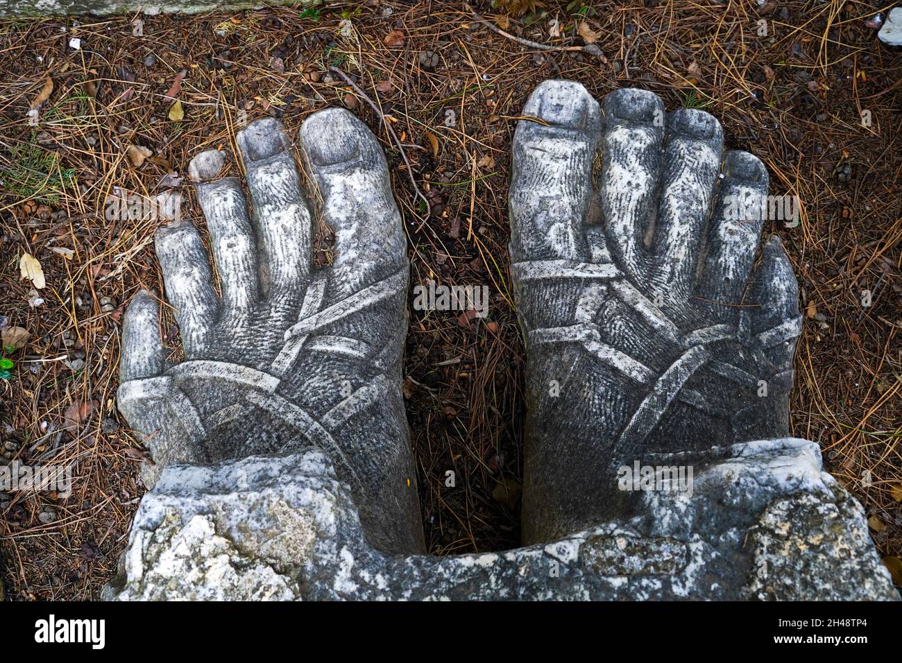 Remains of an ancient broken Greek style stone statue the feet at the ...