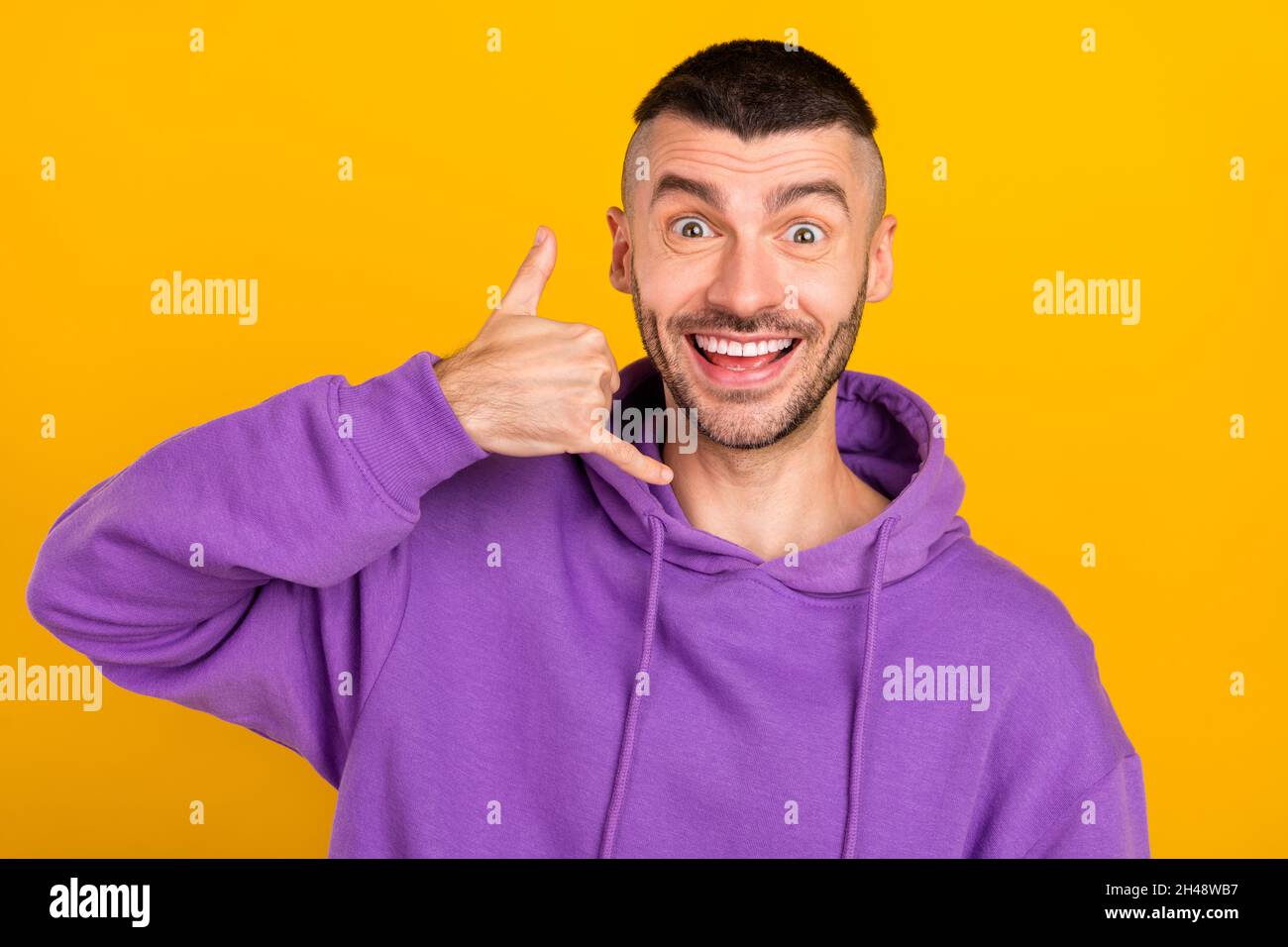 Photo of funny young brunet guy call me wear violet hoodie isolated on ...