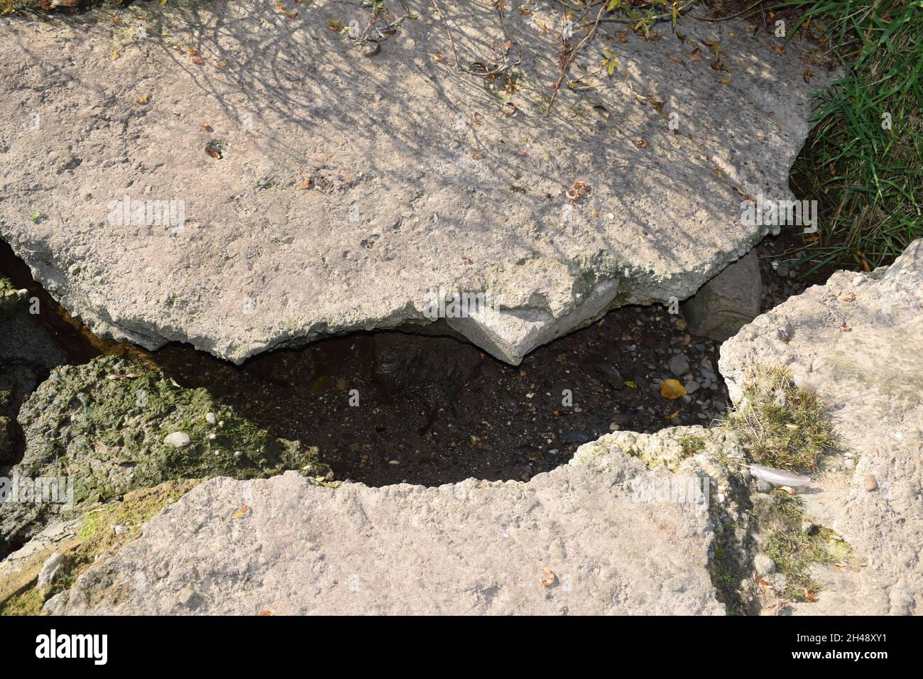 cracked stone ground with inhabited cave Stock Photo - Alamy