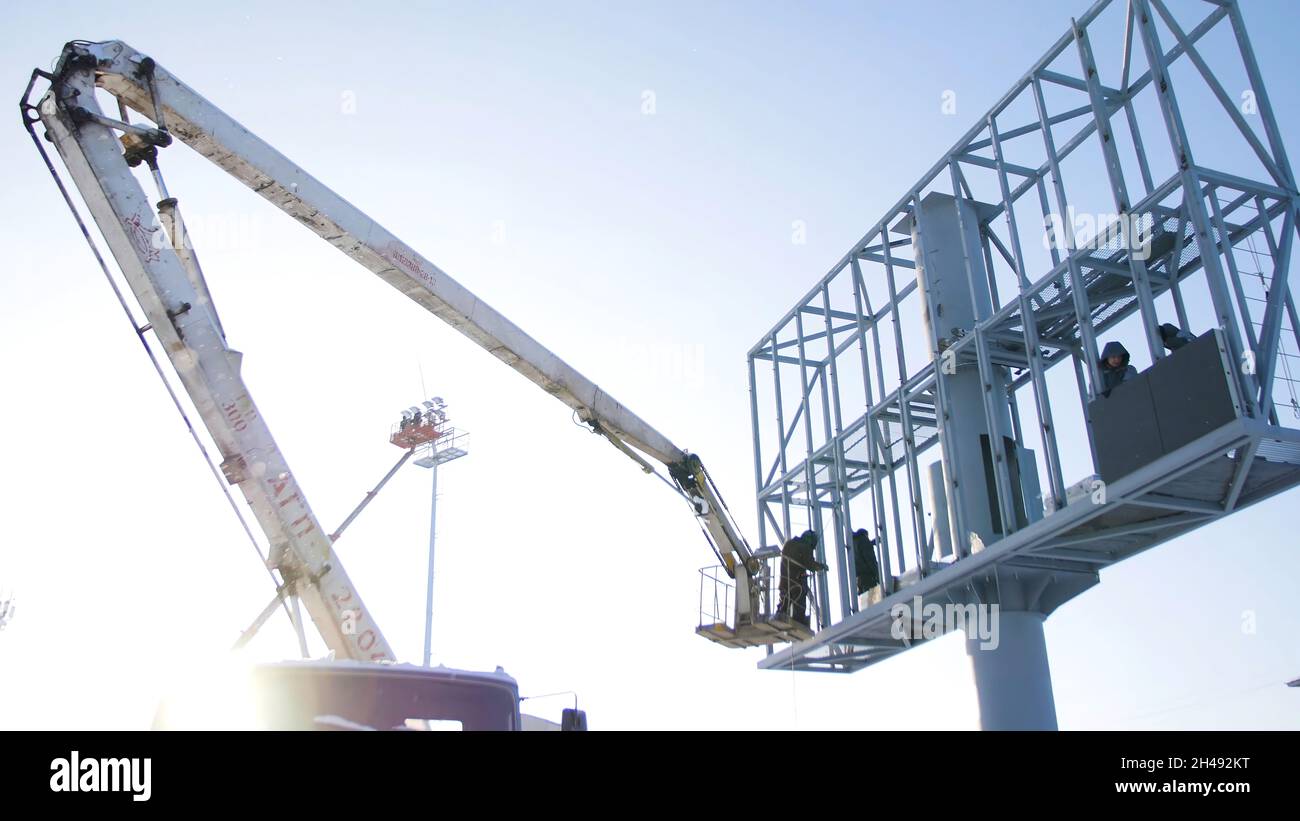 Builder on a Lift Platform at a construction site. Men at work ...