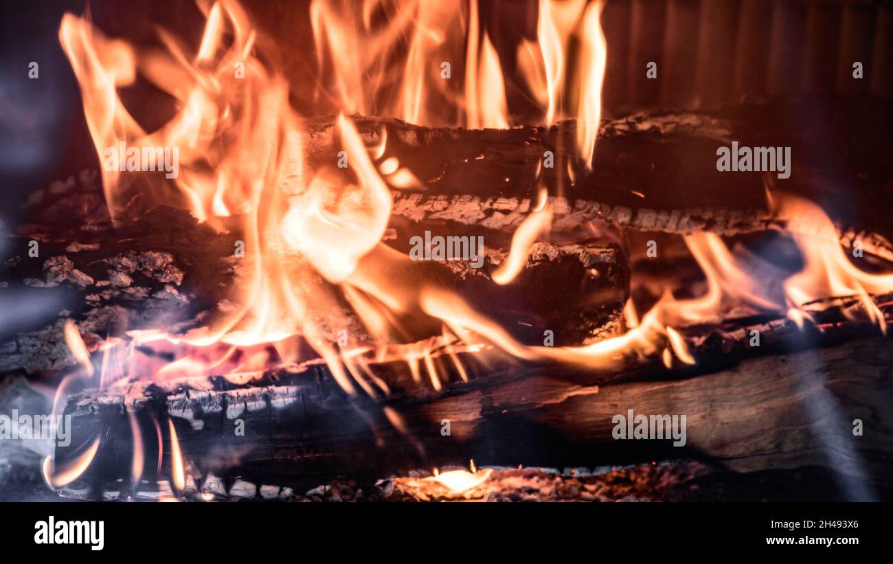 Flames from firewood in the fireplace, fire through the glass, burned ...