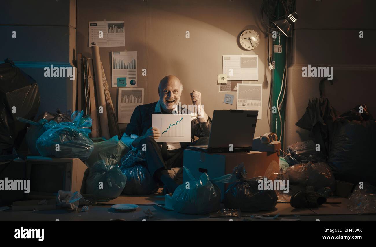 Homeless businessman sitting on the street and showing a successful ...