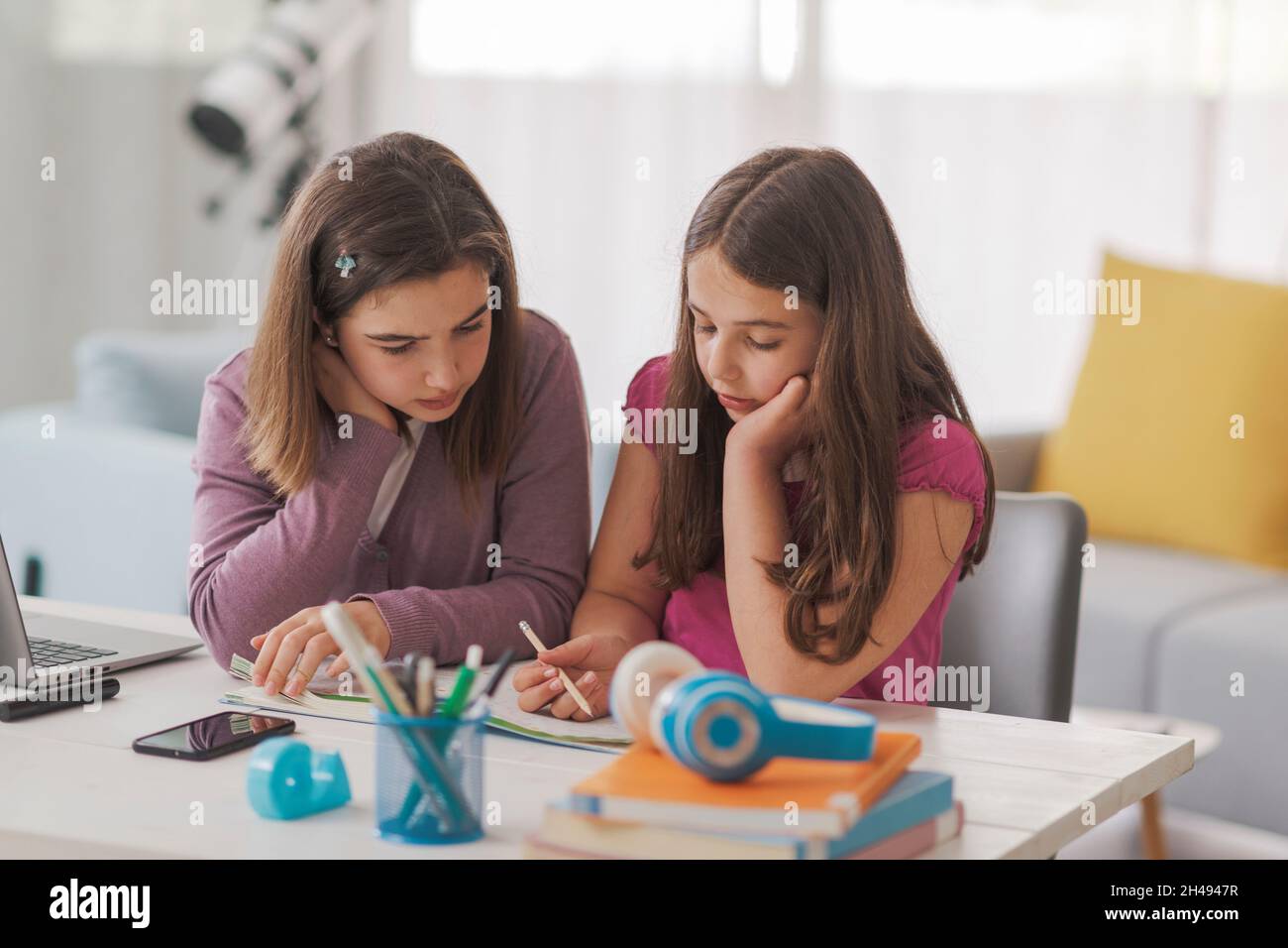Sister helping younger sister homework hi-res stock photography and ...