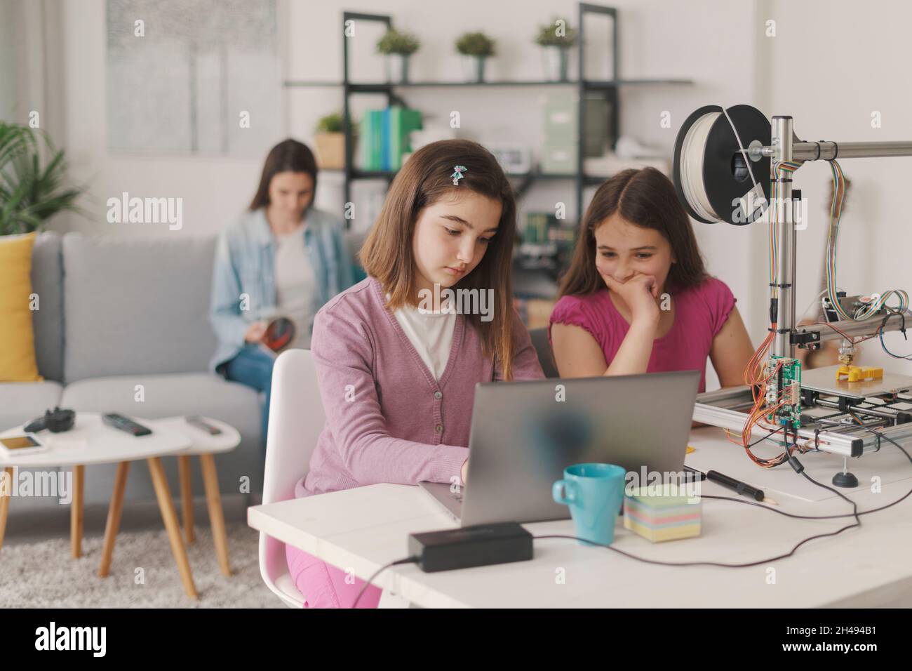 Young smart girls learning 3D printing at home, they are using a 3D ...