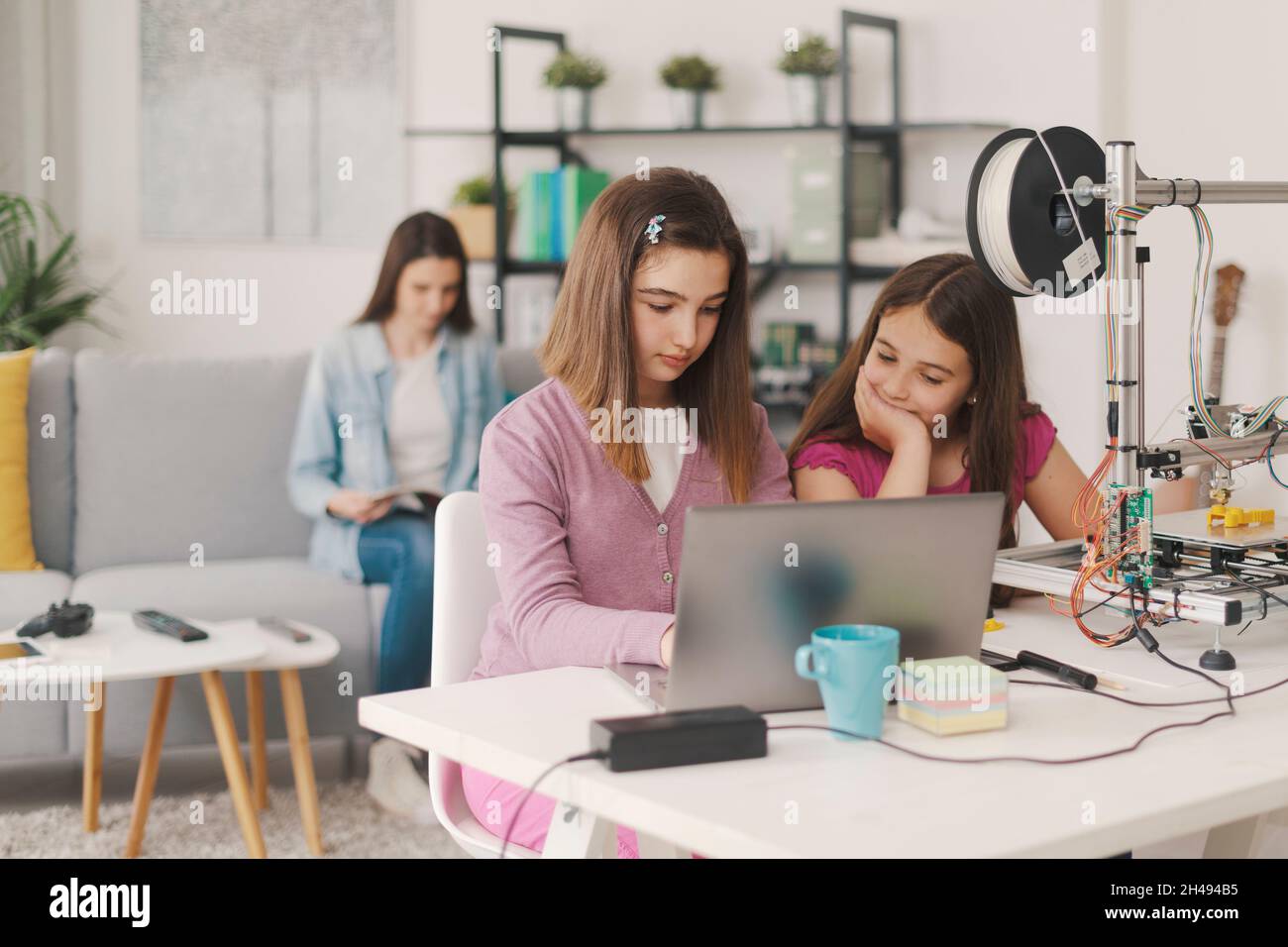 Children learning 3D printing at home, they are using a 3D printer and ...