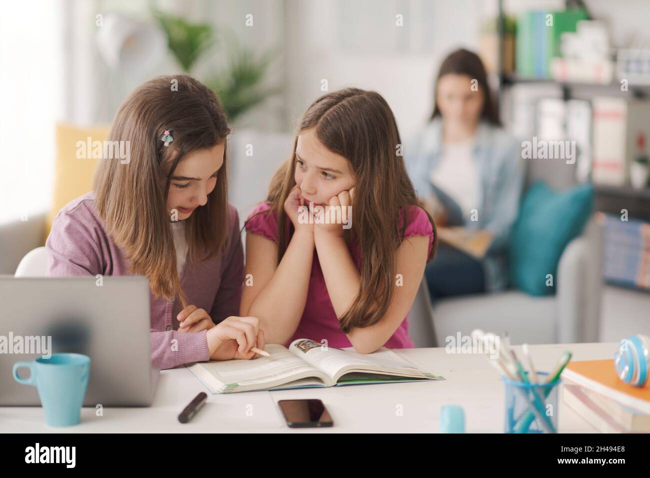 Sister helping younger sister homework hi-res stock photography and ...
