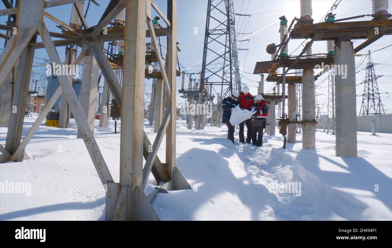 Engineers at electrical substation in winter. Action. Engineers and ...