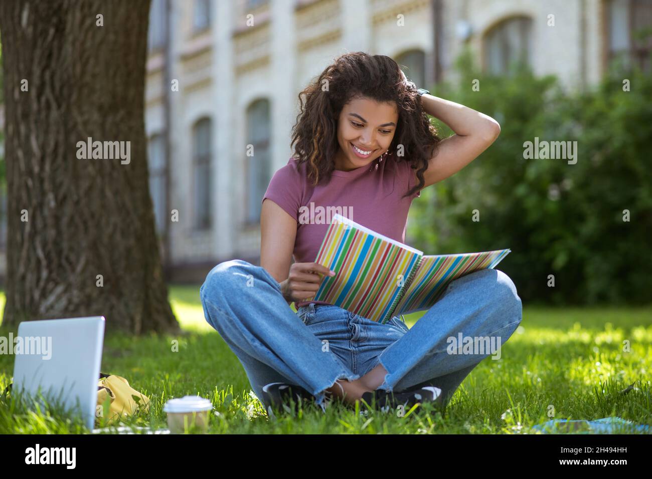 A pretty dark-skinned girl studying on the park Stock Photo - Alamy