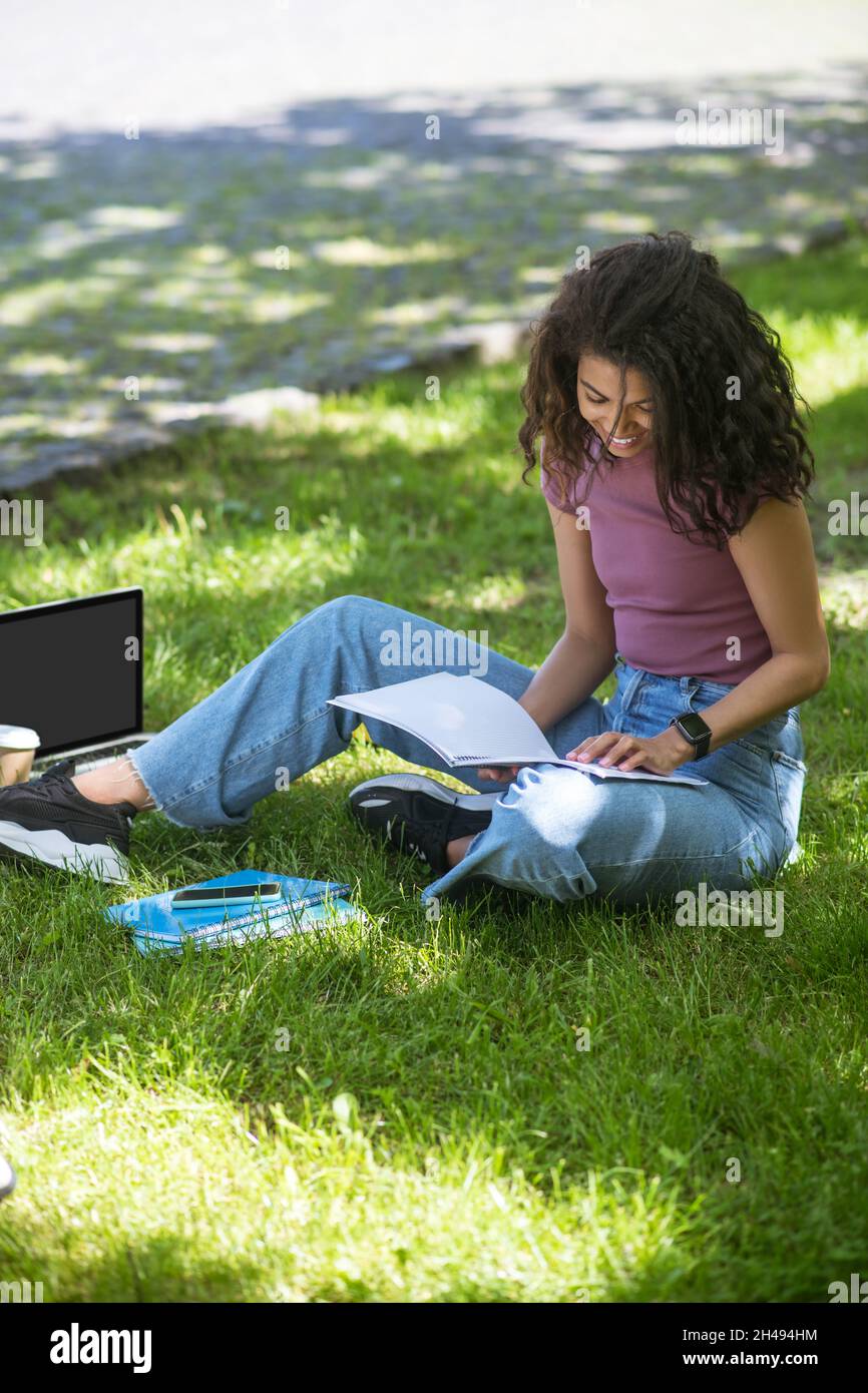 A pretty dark-skinned girl studying on the park Stock Photo - Alamy