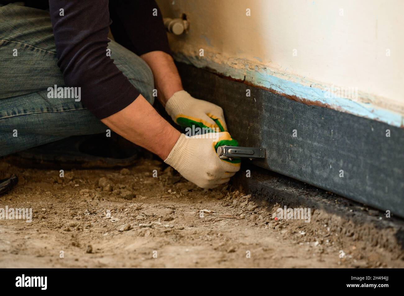 Installing waterproofing in a private house on the floor, a man ...