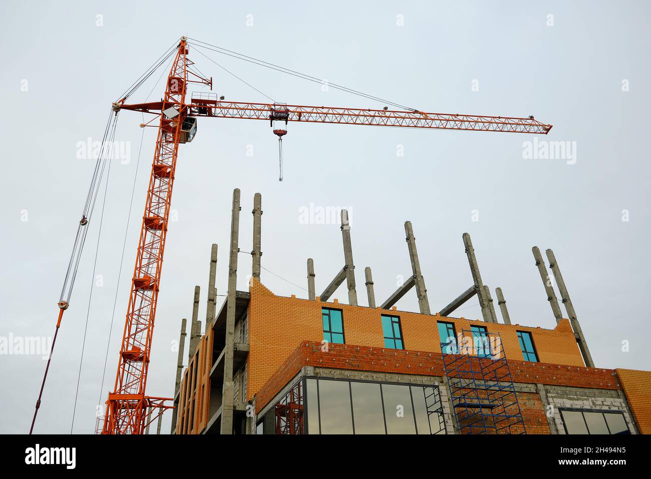 High rise construction crane on background of an unfinished multi ...