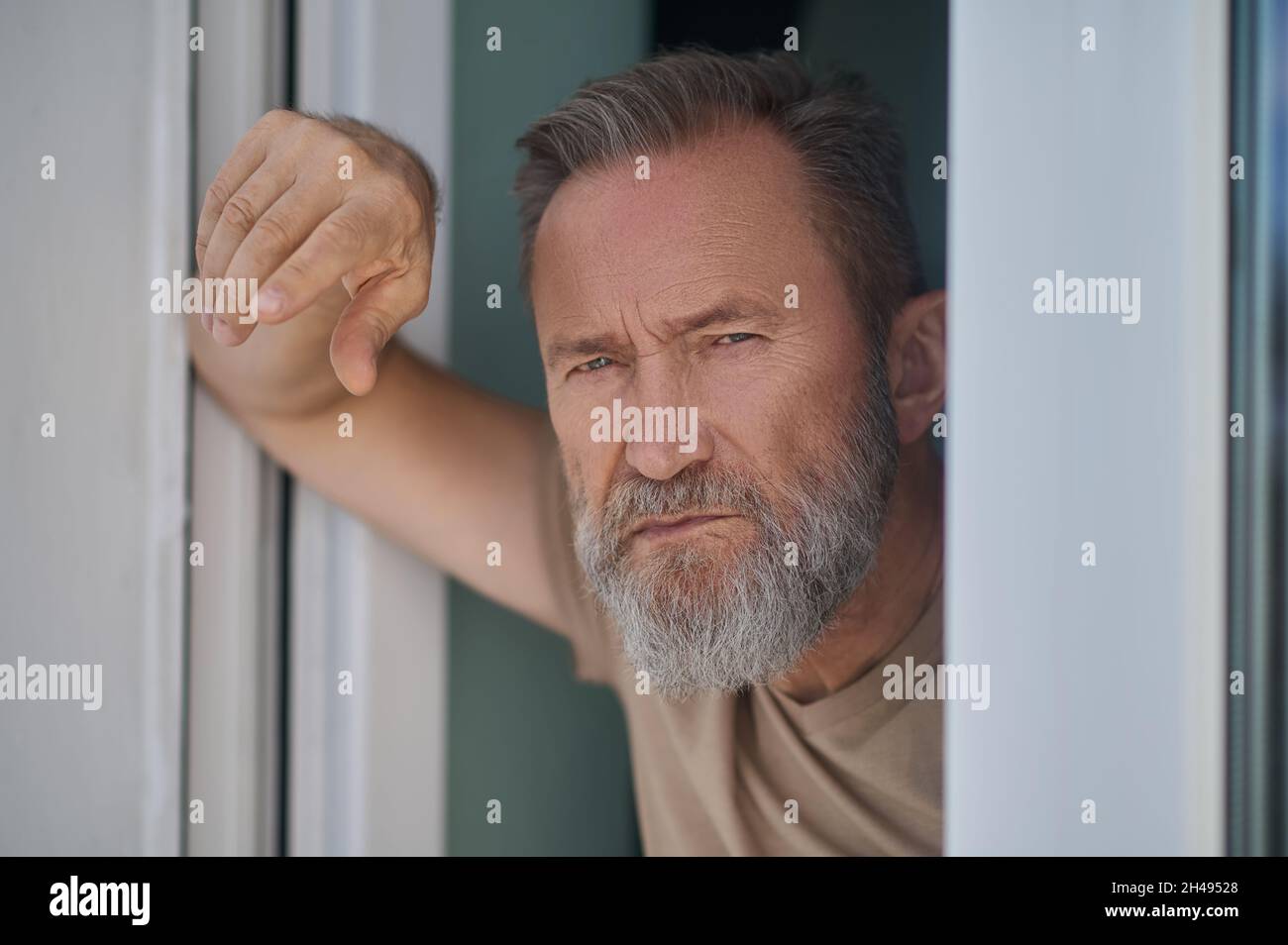 Despondent mature person standing by the window Stock Photo - Alamy
