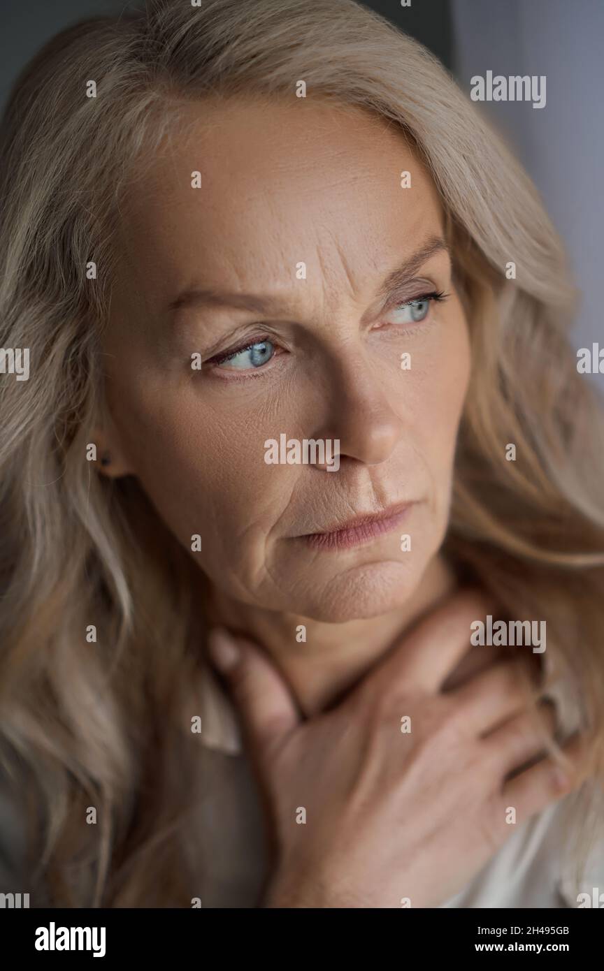 Concerned lovely mature lady staring into the distance Stock Photo - Alamy