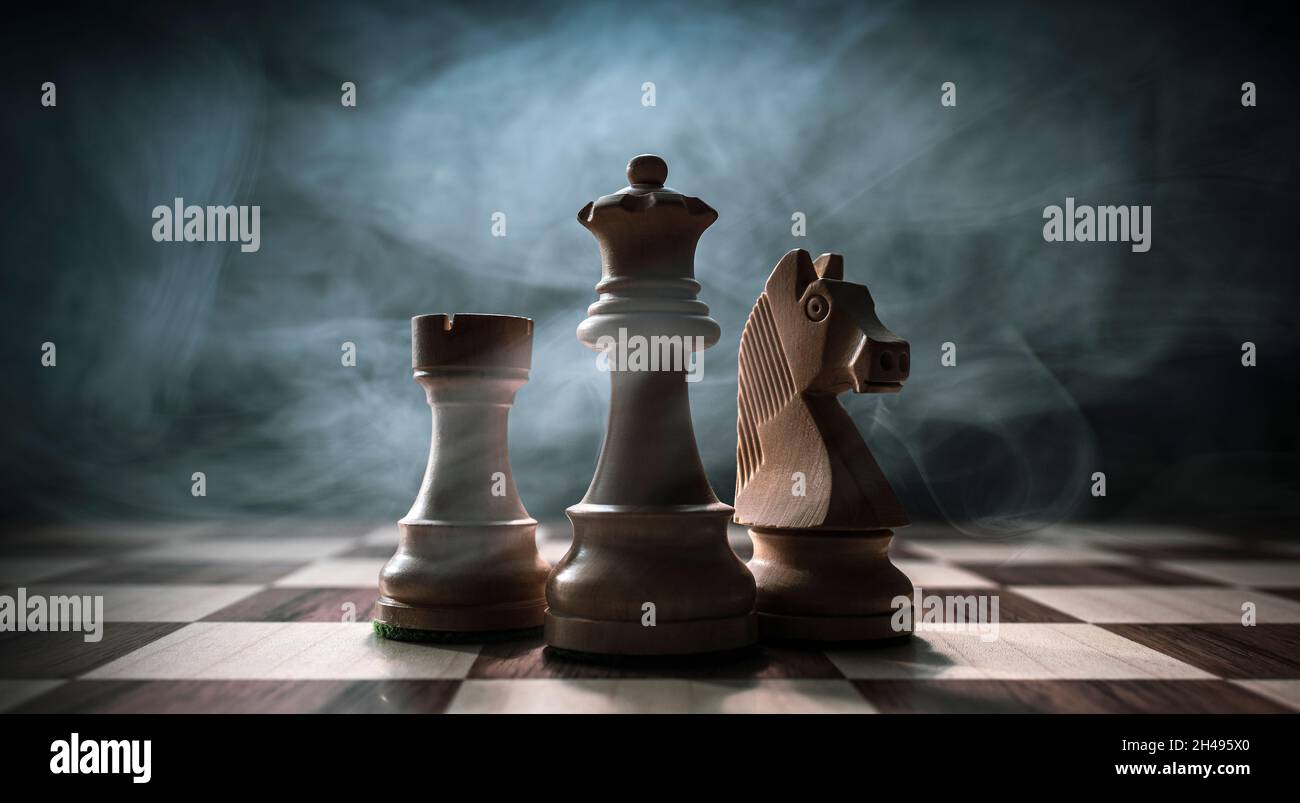 Chess pieces on the chessboard and smoke, games and competition concept ...