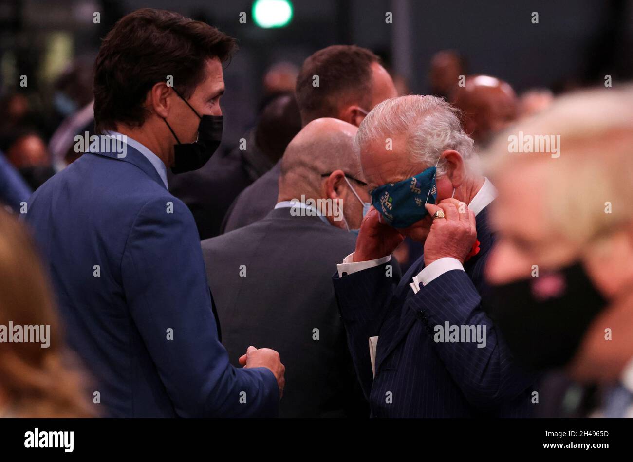 The Prince of Wales adjusts his face mask next to Canada's Prime ...