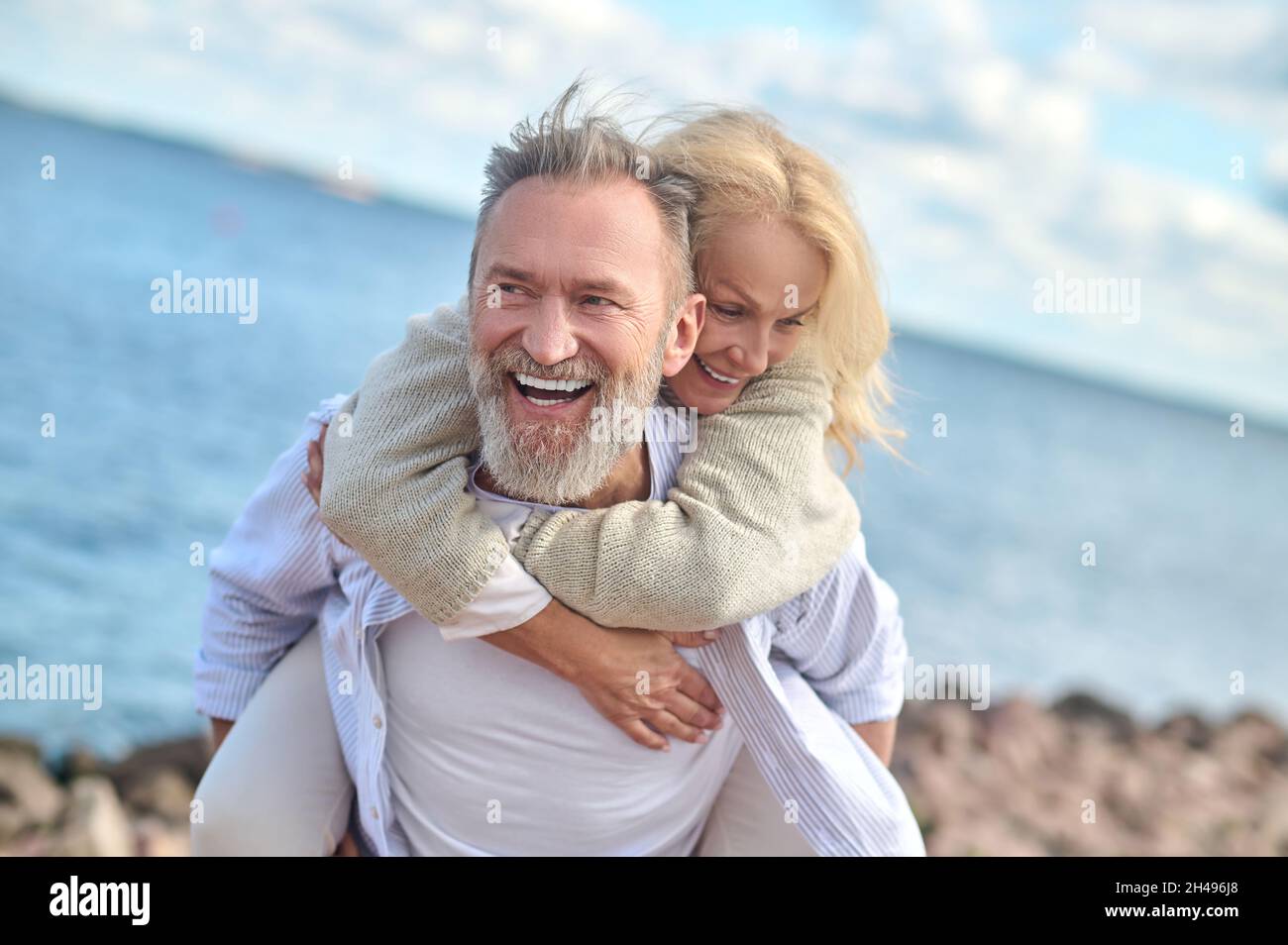 Laughing man carrying woman on his back Stock Photo - Alamy