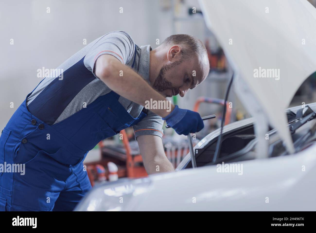 Mechanic fixing a car engine in the auto repair shop Stock Photo - Alamy