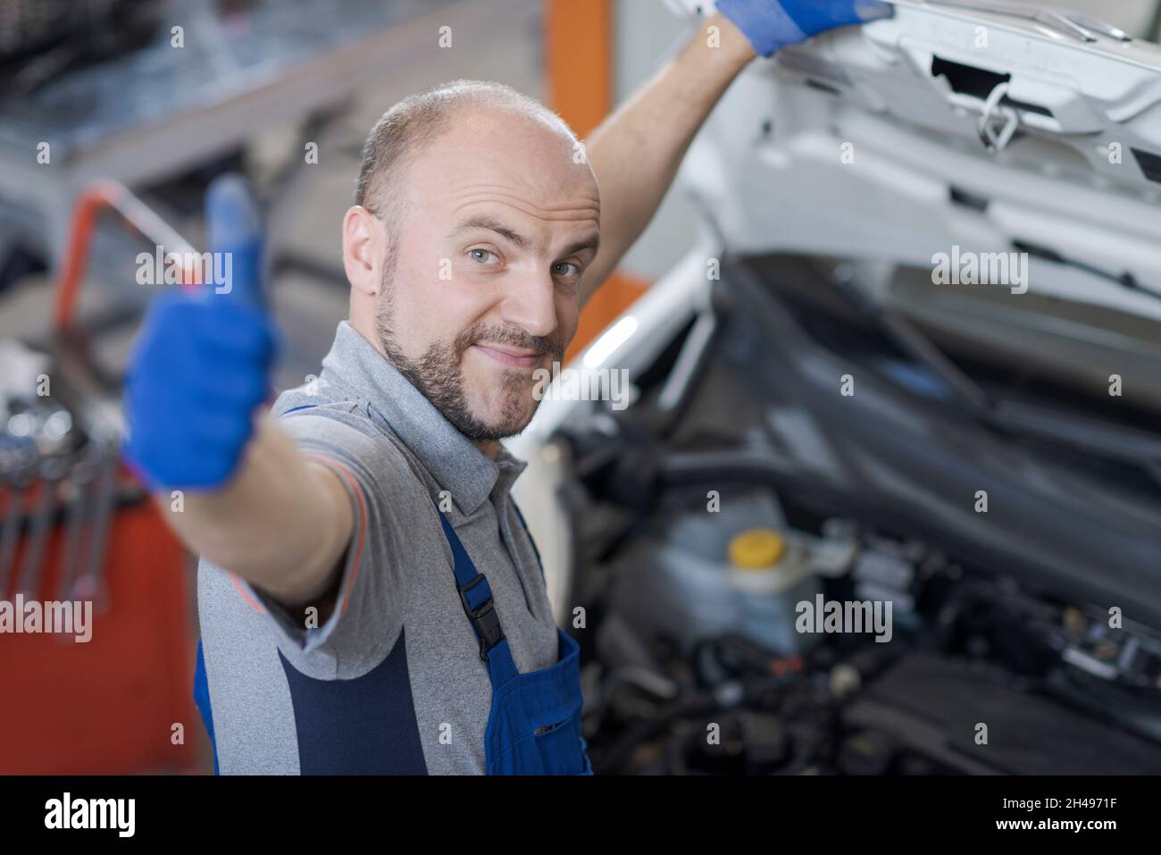 Smiling mechanic giving a thumbs up after checking the car Stock Photo ...