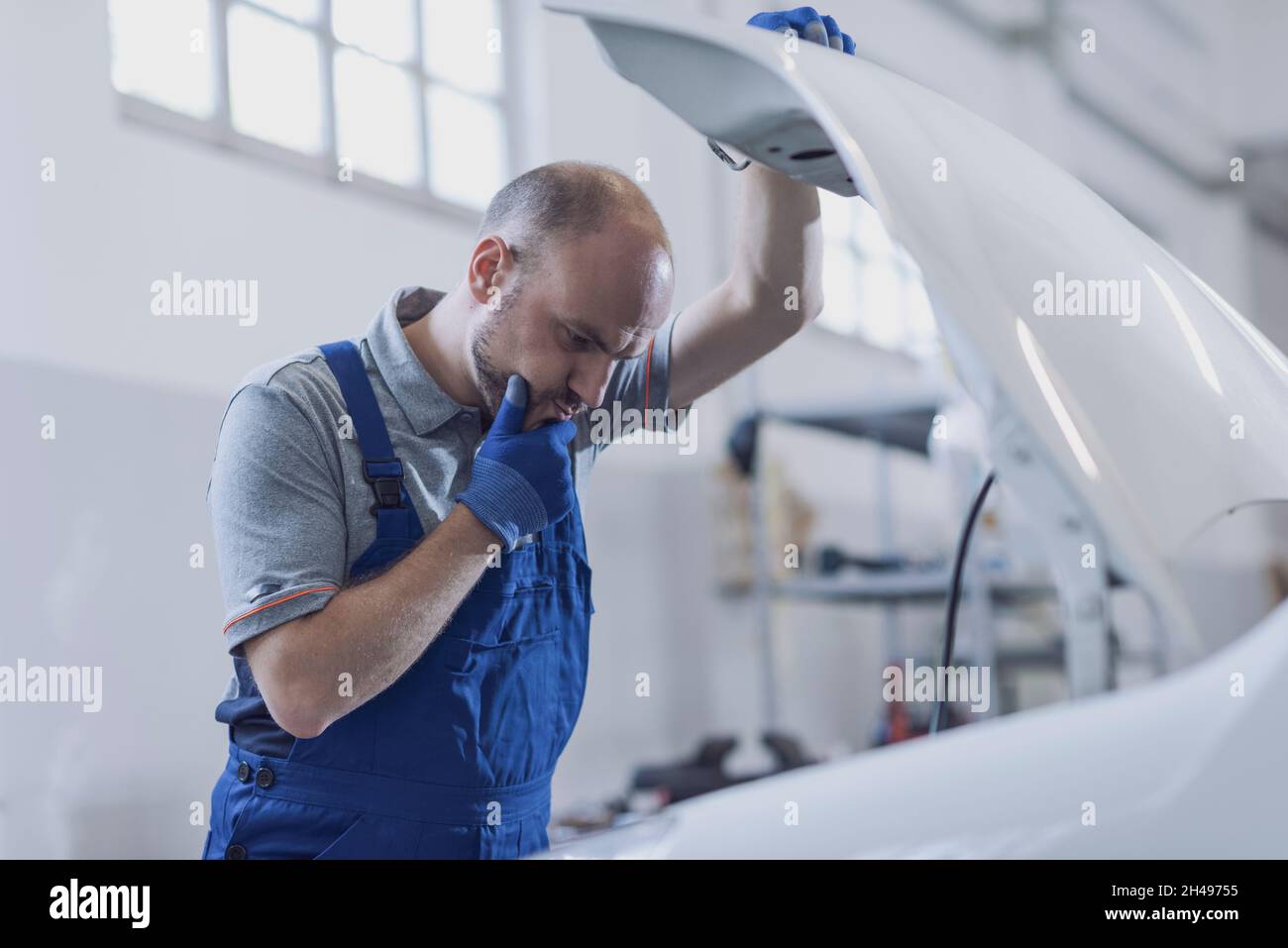 Professional mechanic doing a car inspection and checking the engine ...