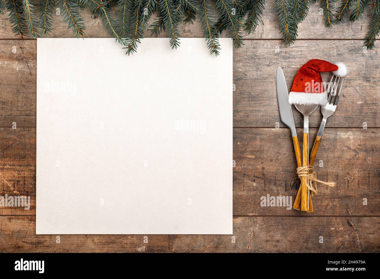 Christmas tree decorations border on vintage wooden table with cutlery ...