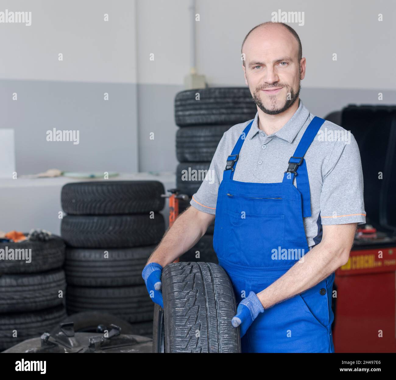 Professional smiling mechanic posing in the auto repair station, he is ...