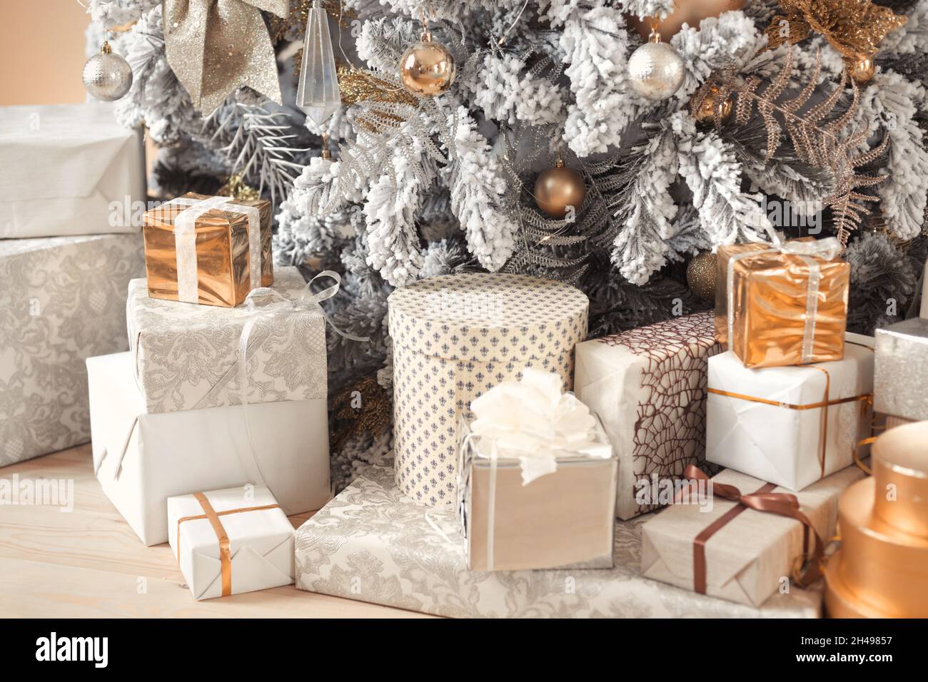 Christmas presents under a luxury rich decorated snow-covered tree in ...