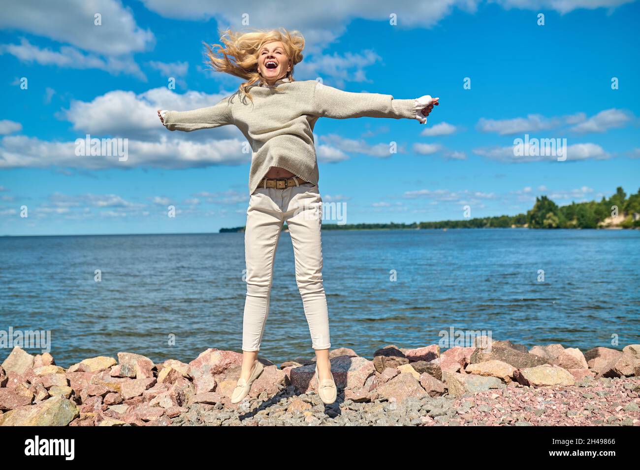Pretty blonde woman jumping hi-res stock photography and images - Alamy