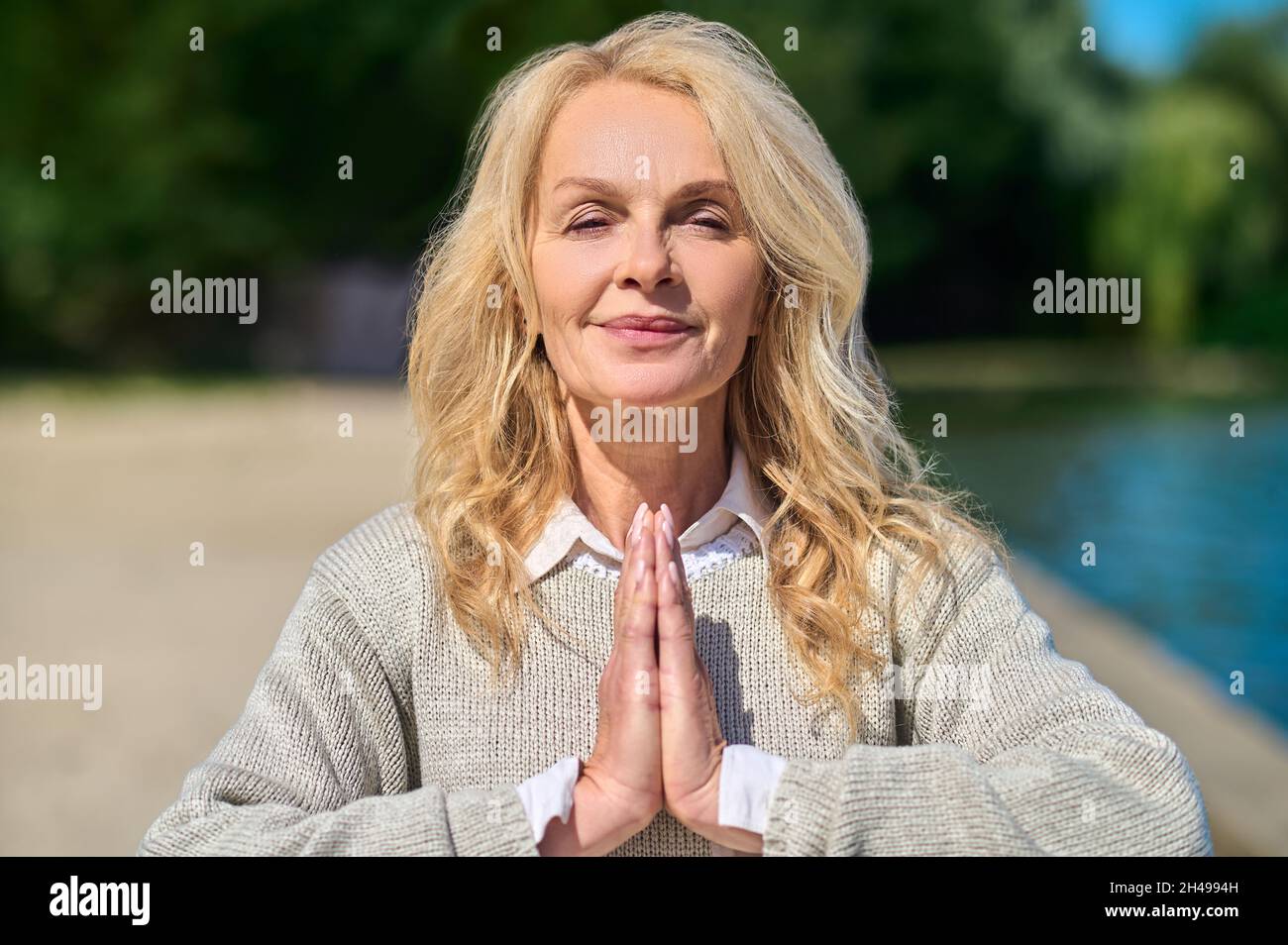 Smiling beautiful woman in namaste pose Stock Photo - Alamy