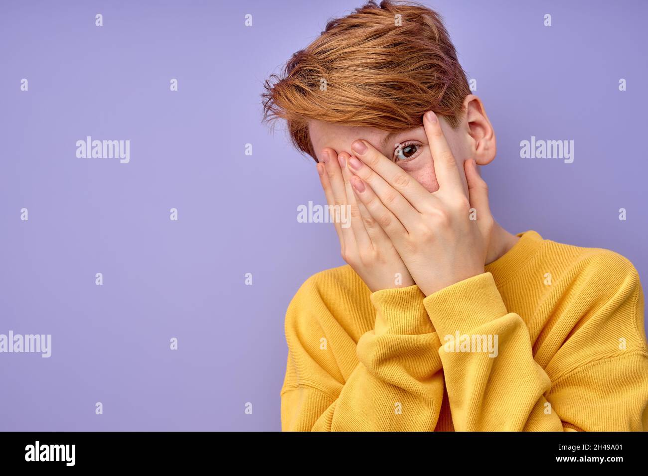 Portrait of scared caucasian teen boy, isolated on purple background ...