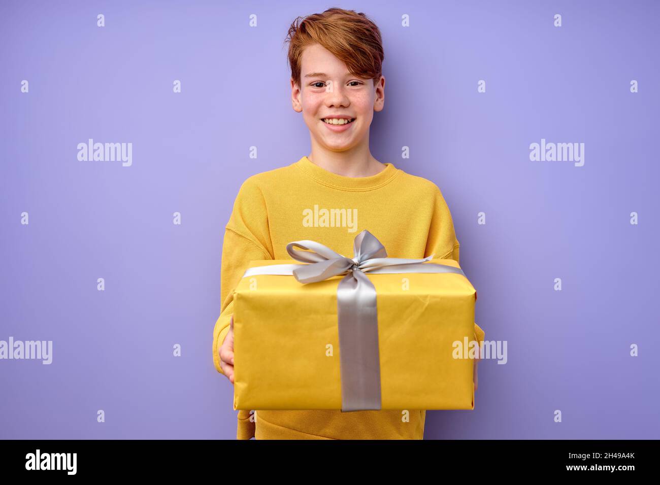 Amusing happy pleased little boy holding gift box in hands, attractive ...
