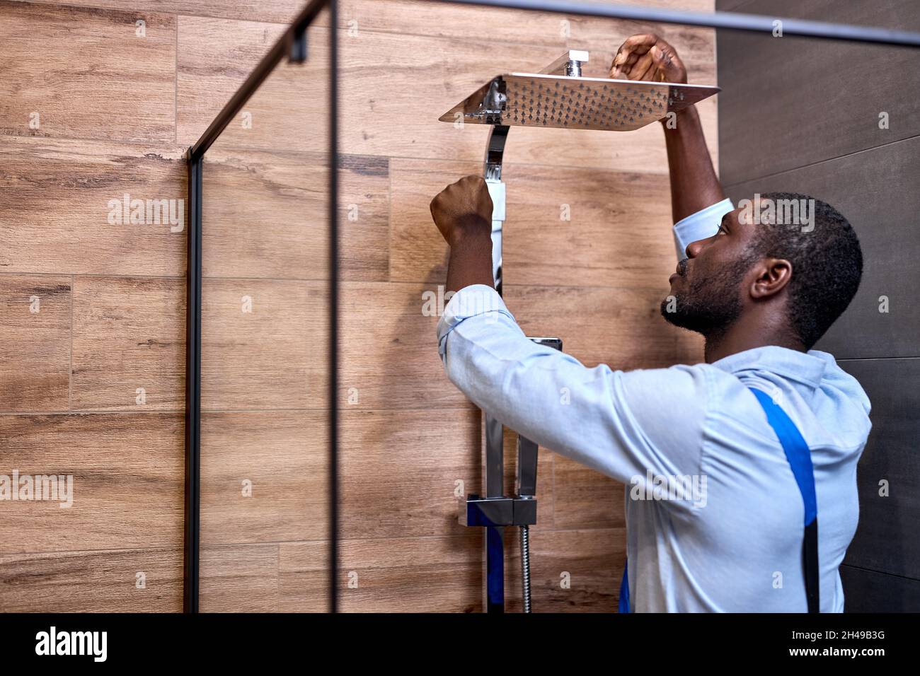 Afro american Professional handyman working in shower bath indoors ...