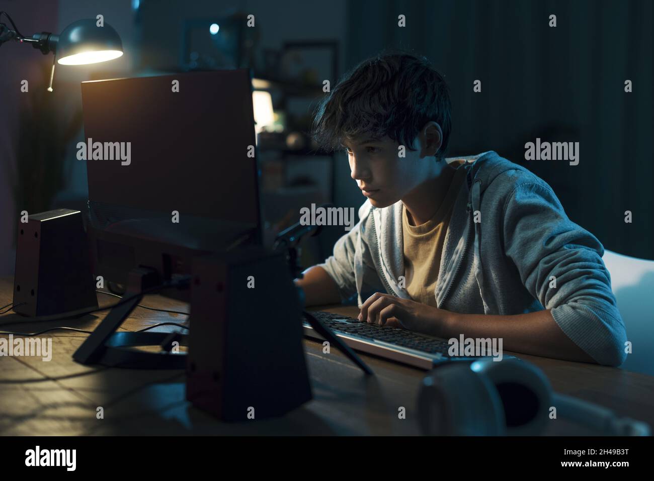 Boy connecting online at night and playing video games, entertainment ...