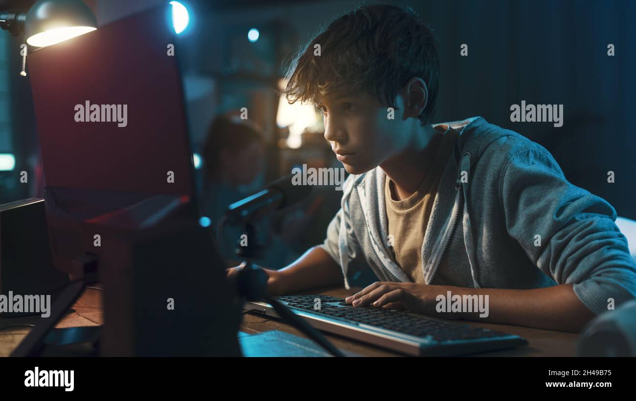 Boy connecting online at night and playing video games, entertainment ...