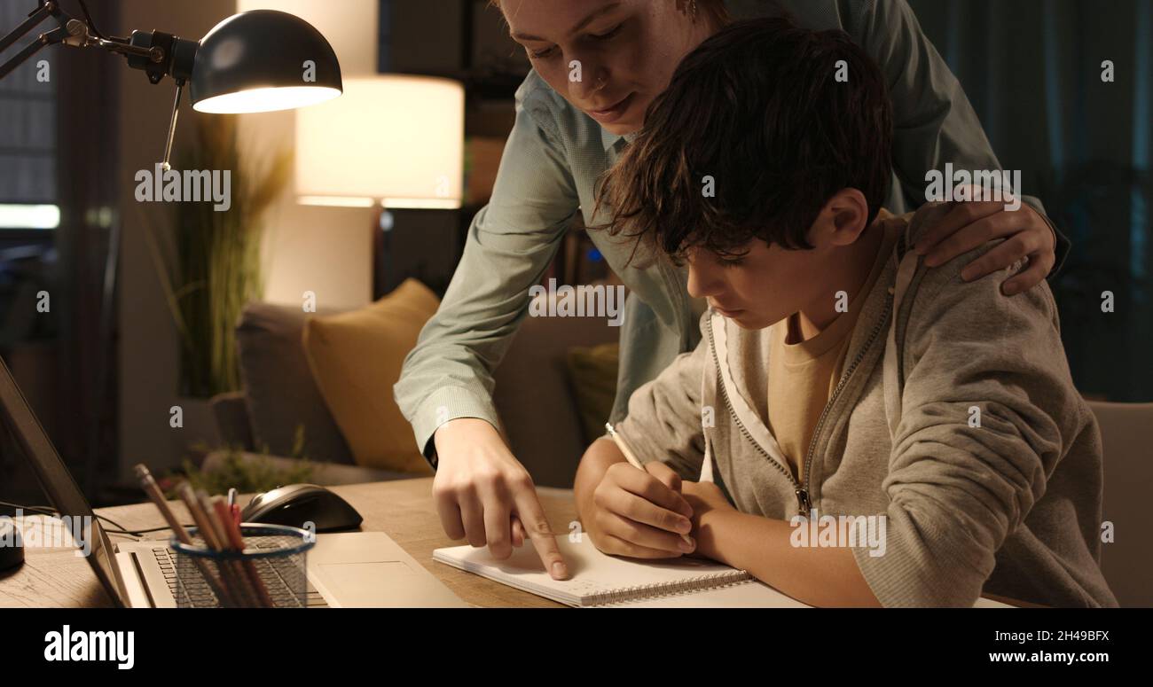 Caring sister helping her younger brother with school homework Stock ...