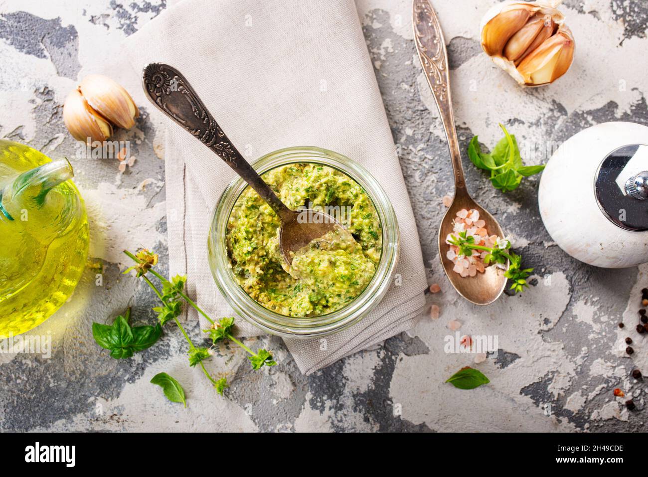 Homemade parsley pesto sauce and ingredients on dark cement background ...