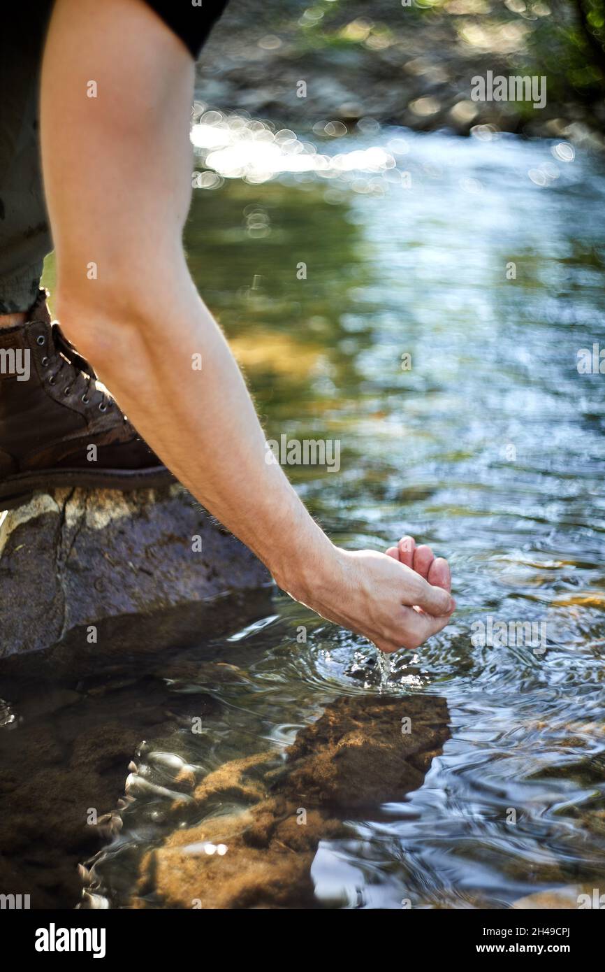 Man taking pure water from river, closeup, side view. Nature healing ...