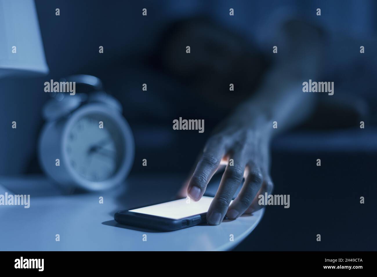 Woman sleeping in her bed and receiving a phone call late at night, she ...