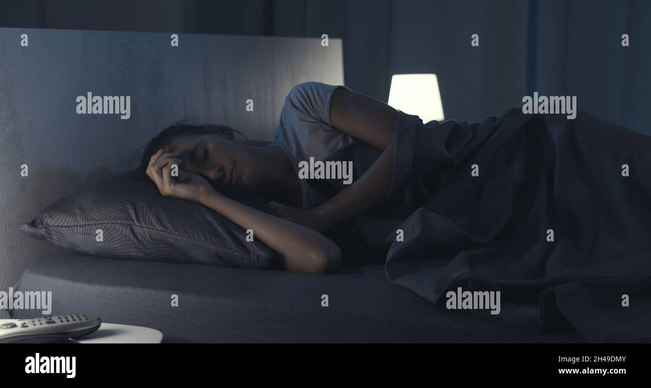 Woman sleeping in her bed at night, she is calm and relaxed Stock Photo ...