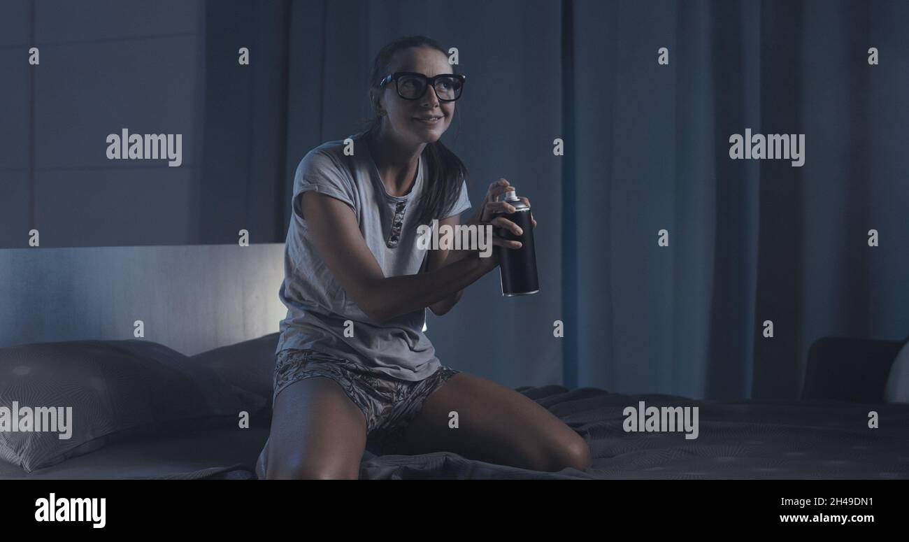 Woman killing mosquitoes in her bedroom using a spray insecticide Stock ...