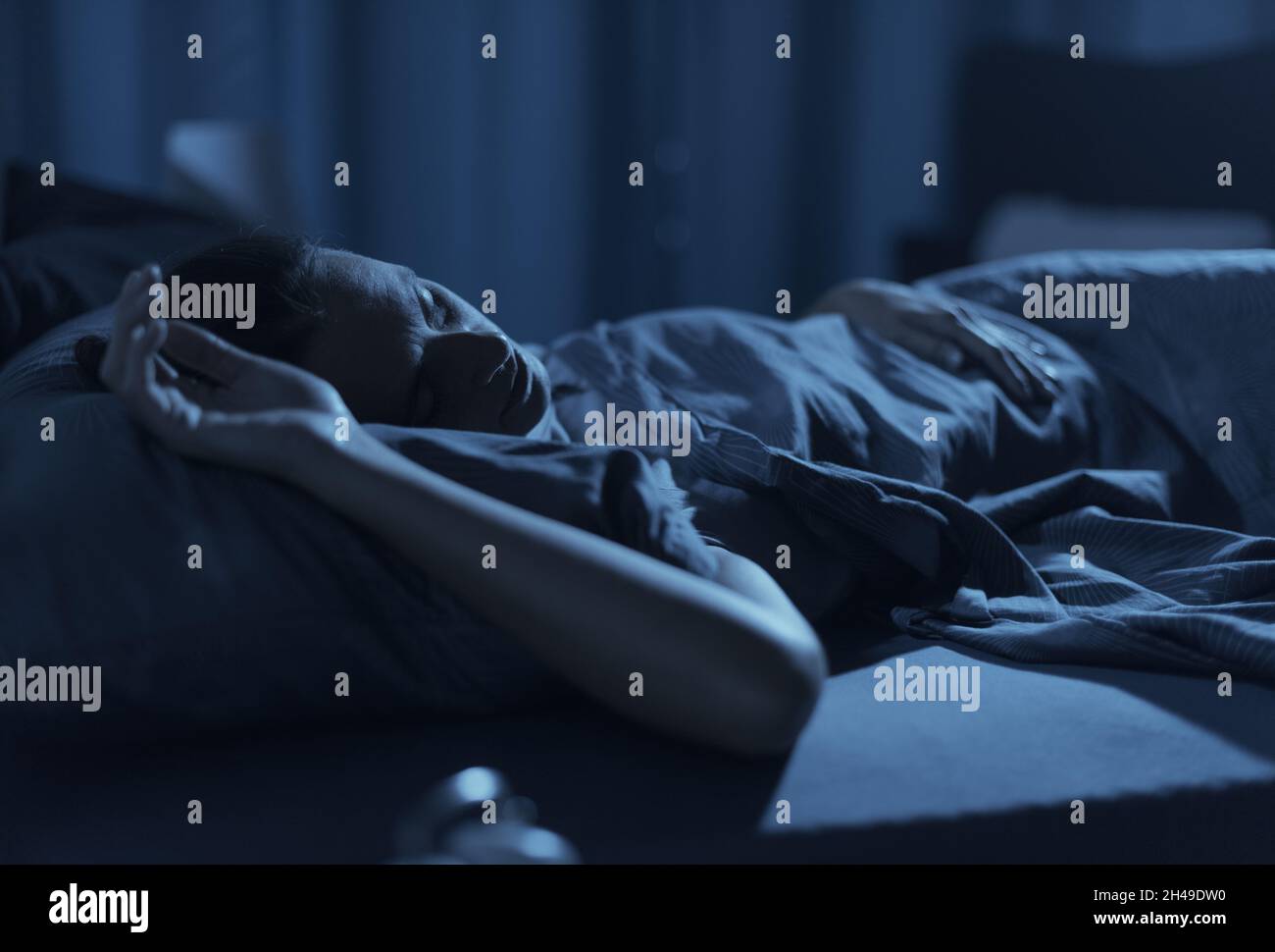 Woman sleeping in her bed at night, she is calm and relaxed Stock Photo ...
