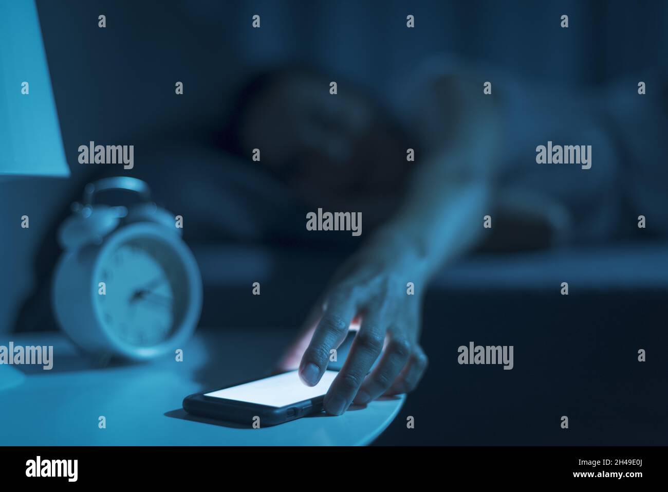 Woman sleeping in her bed and receiving a phone call late at night, she ...