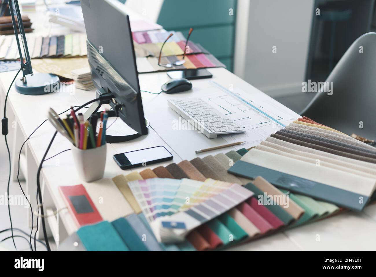 Interior designer work desktop with computer, fabric swatches and house ...