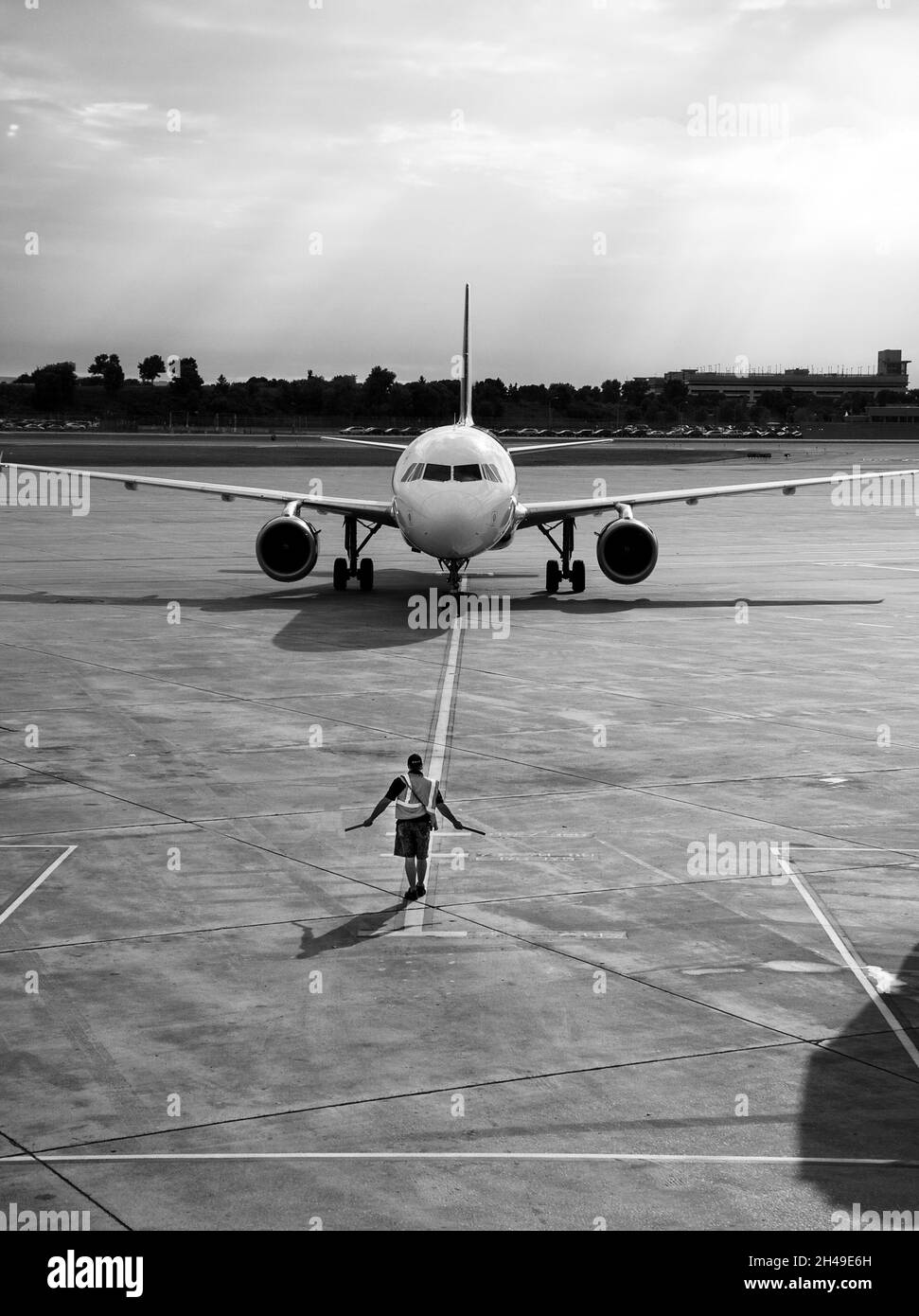 Ramp agent signalling the approaching aircraft at the airport in ...
