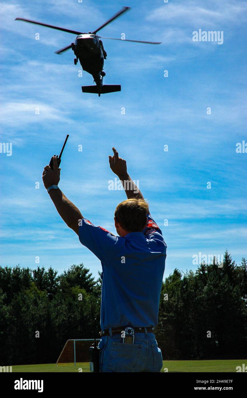 Adult firefighter signalling the arrival of a helicopter in East Troy ...
