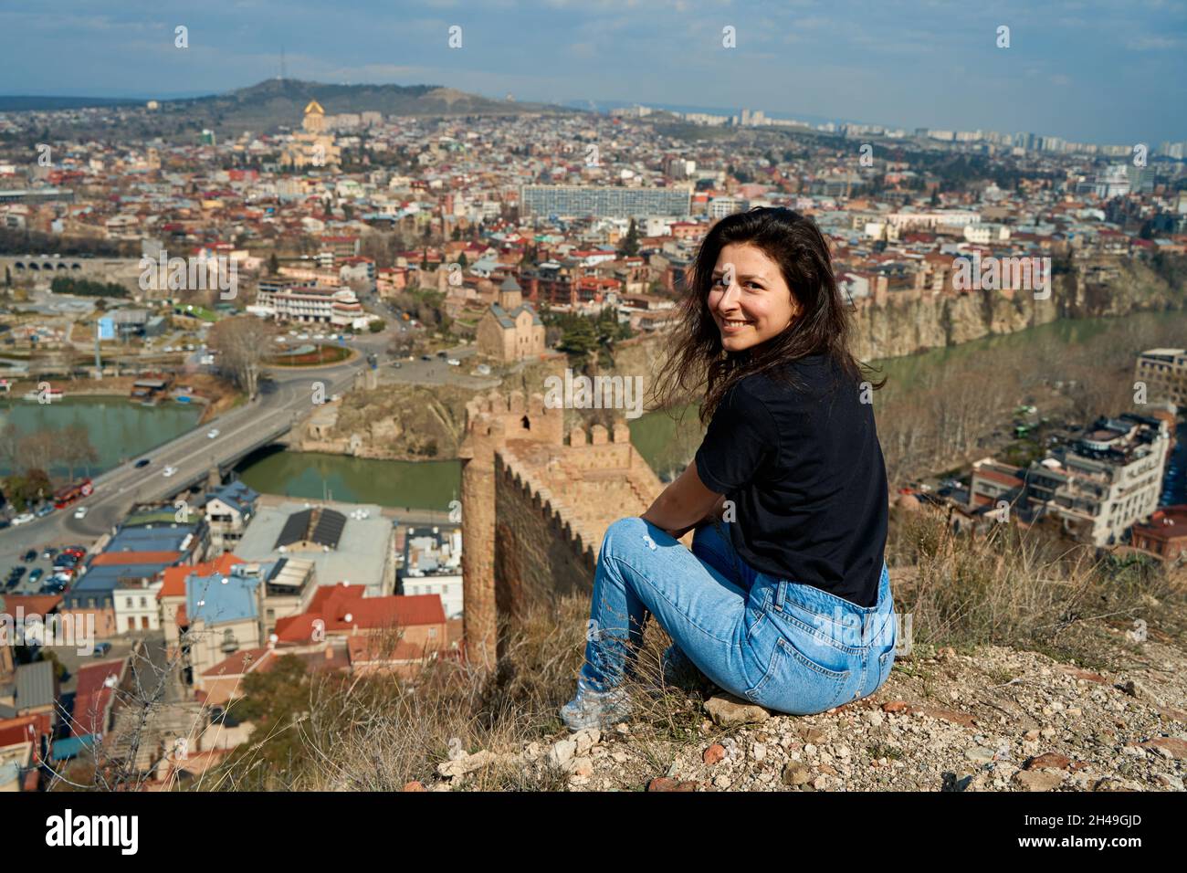 A cute brunette girl enjoys the stunning scenery of Tbilisi from the ...