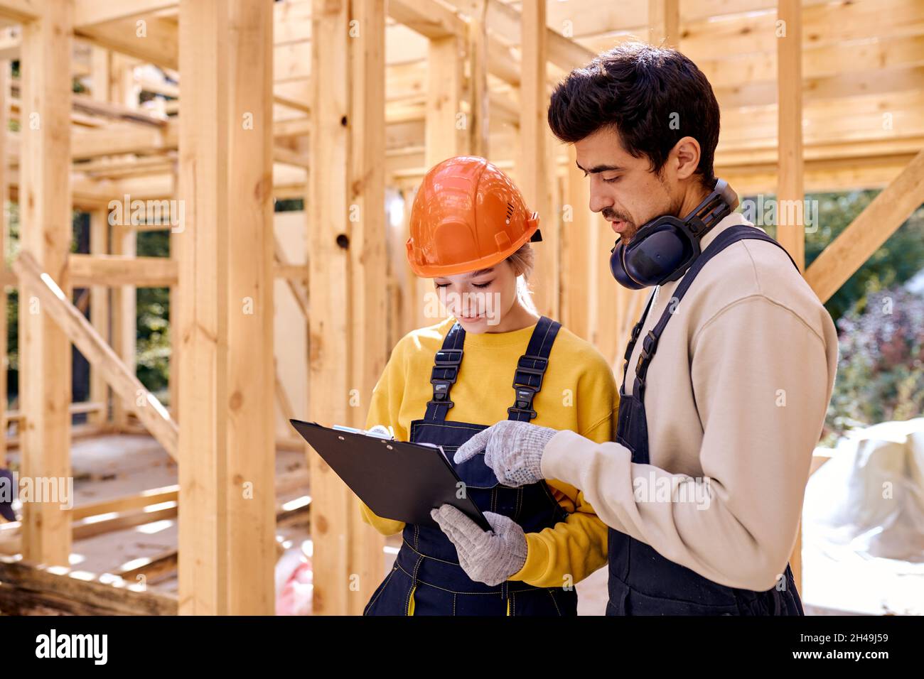 Two caucasian hardworking civil engineers dressed in uniform explore ...